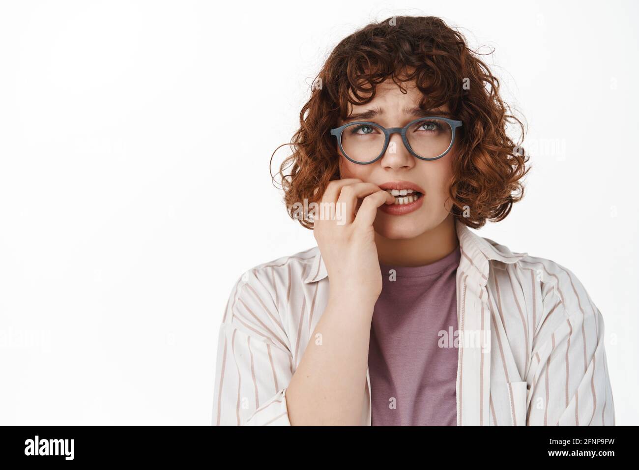 Anxious girl student in glasses, woman biting fingernails and looking ...
