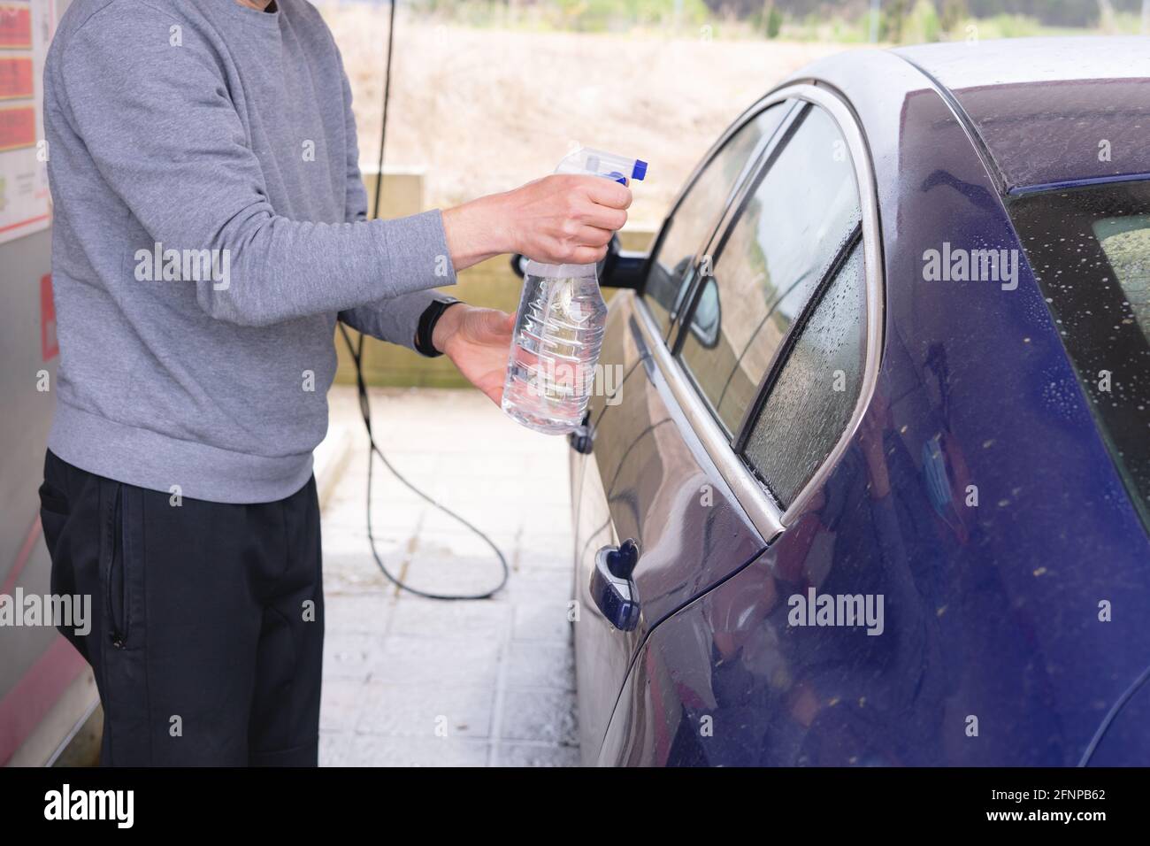 Man cleaning car with spray bottle. Car wash Stock Photo - Alamy
