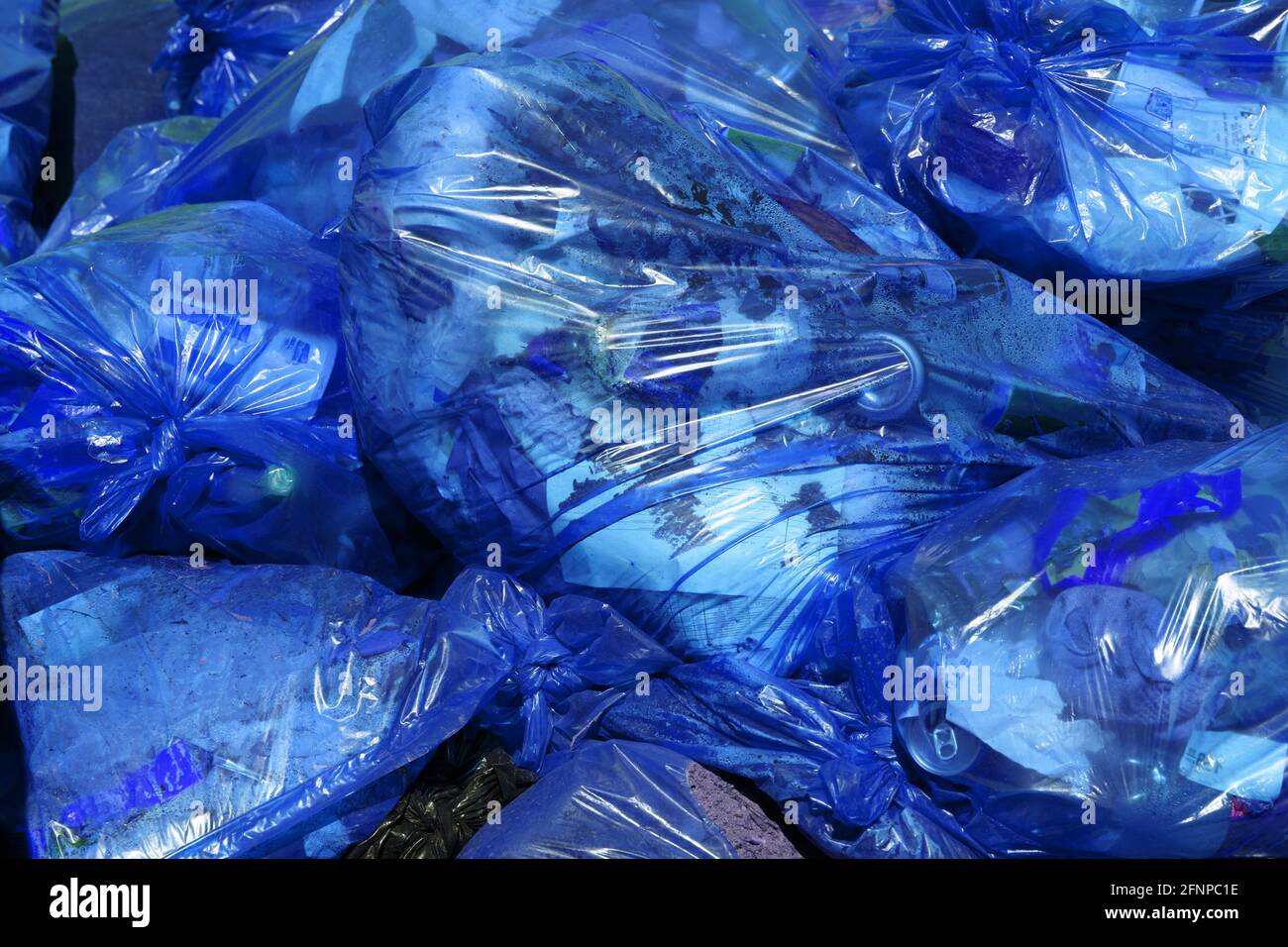 full frame background of blue plastic trash bags with generic domestic ...