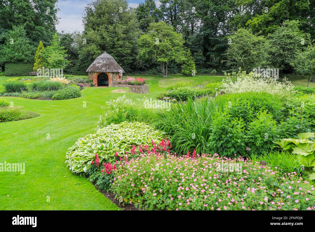 The thatched roof Dell Summer House, Bressingham Gardens, a steam ...