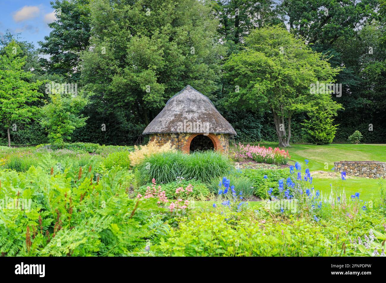 The thatched roof Dell Summer House, Bressingham Gardens, a steam ...