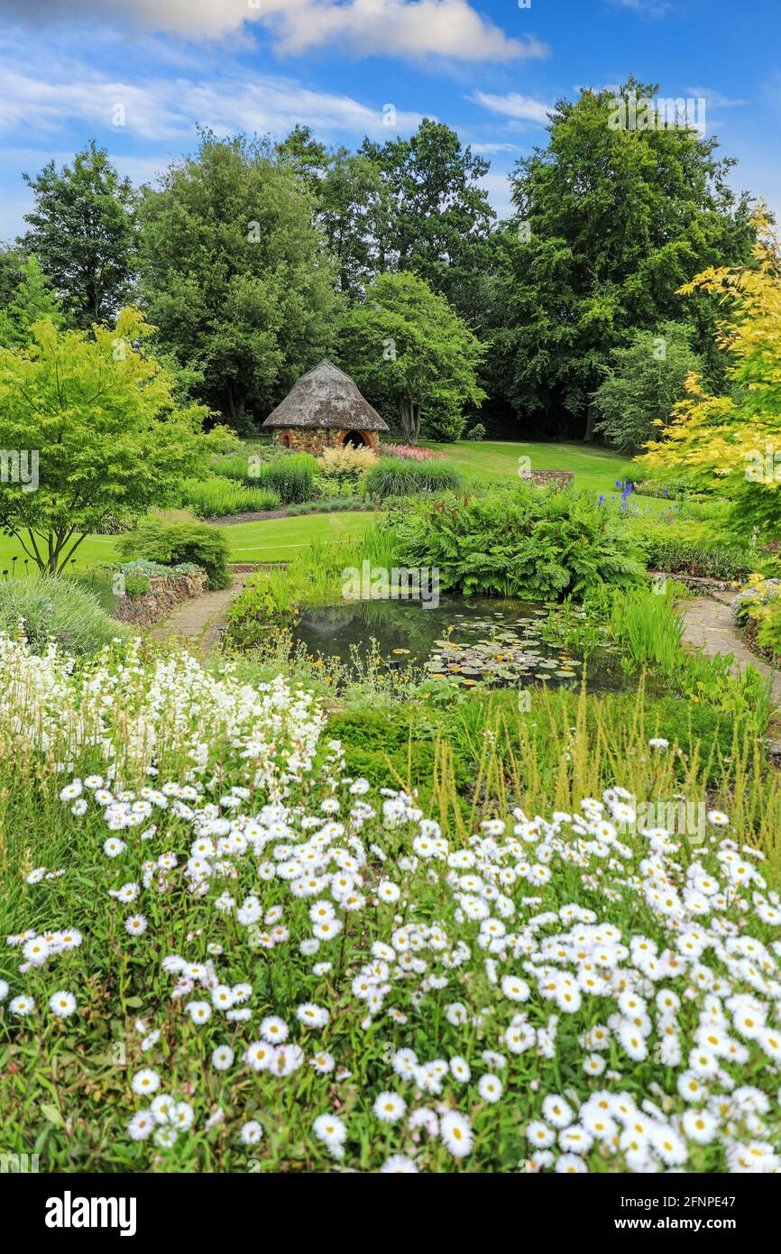 The thatched roof Dell Summer House, Bressingham Gardens, a steam ...