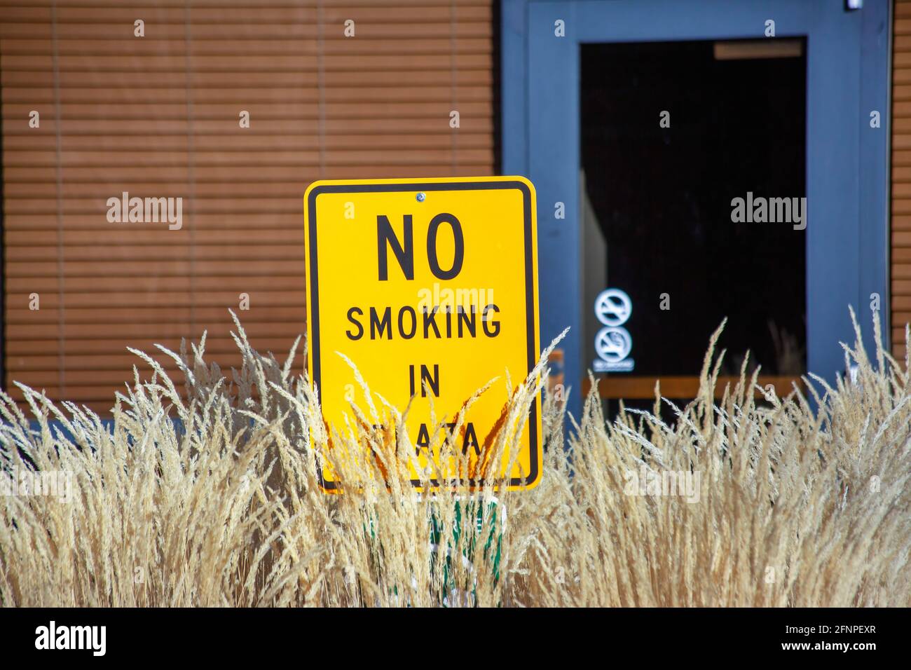 Yellow now smoking sign in front of a building in the grass Stock Photo ...