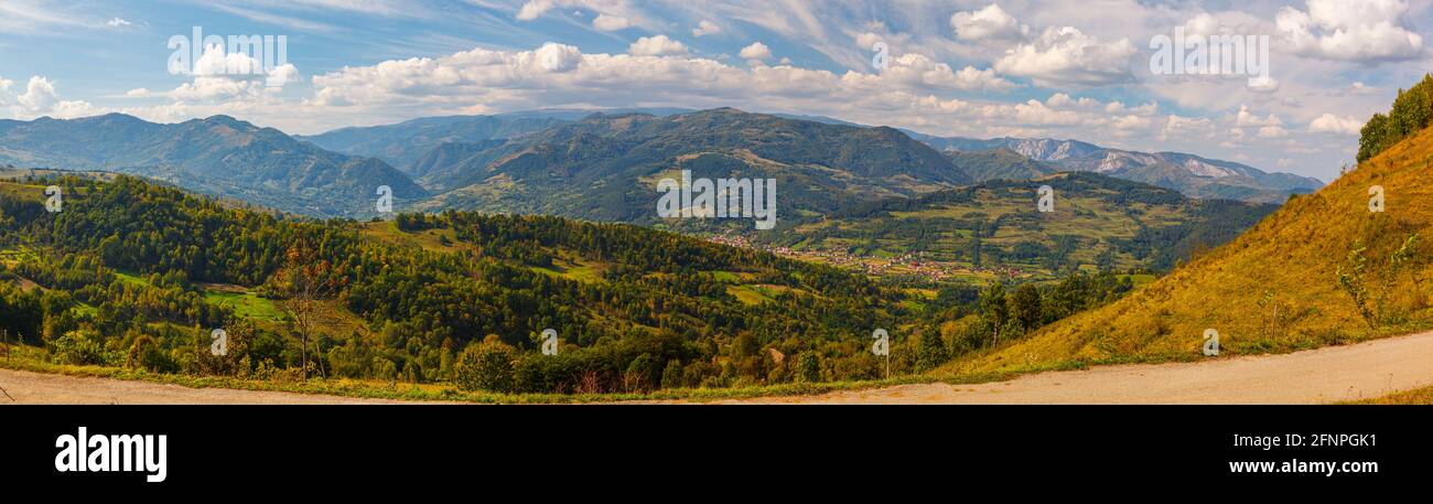 Wide panorama of a small romanian village surrounded by green hills and ...