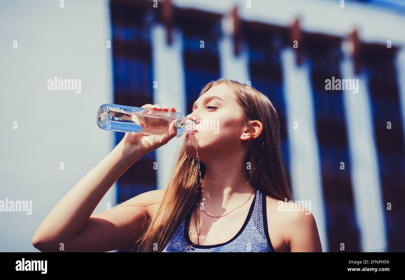 beautiful female runner drinking water. Fitness woman taking a break ...
