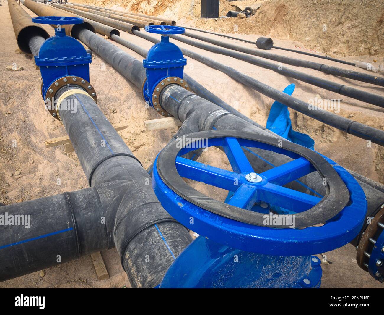 Valves on pipeline in ground. Pipe valves in trench Stock Photo - Alamy