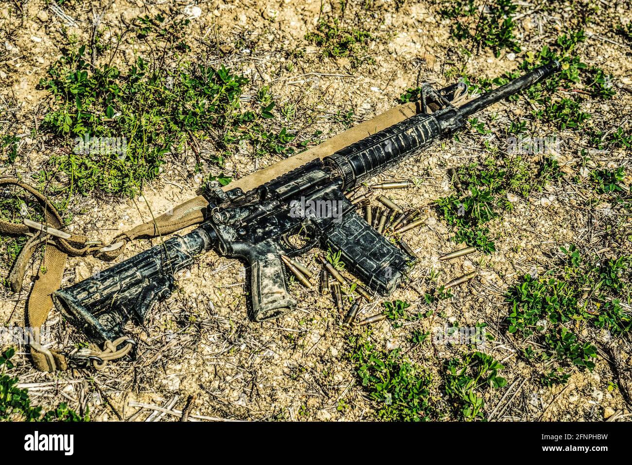 A modern automatic American carbine lying on the ground in the mud ...