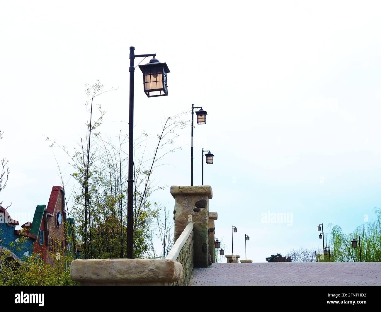 Decorative street lamps line up along the bridge in the park against ...