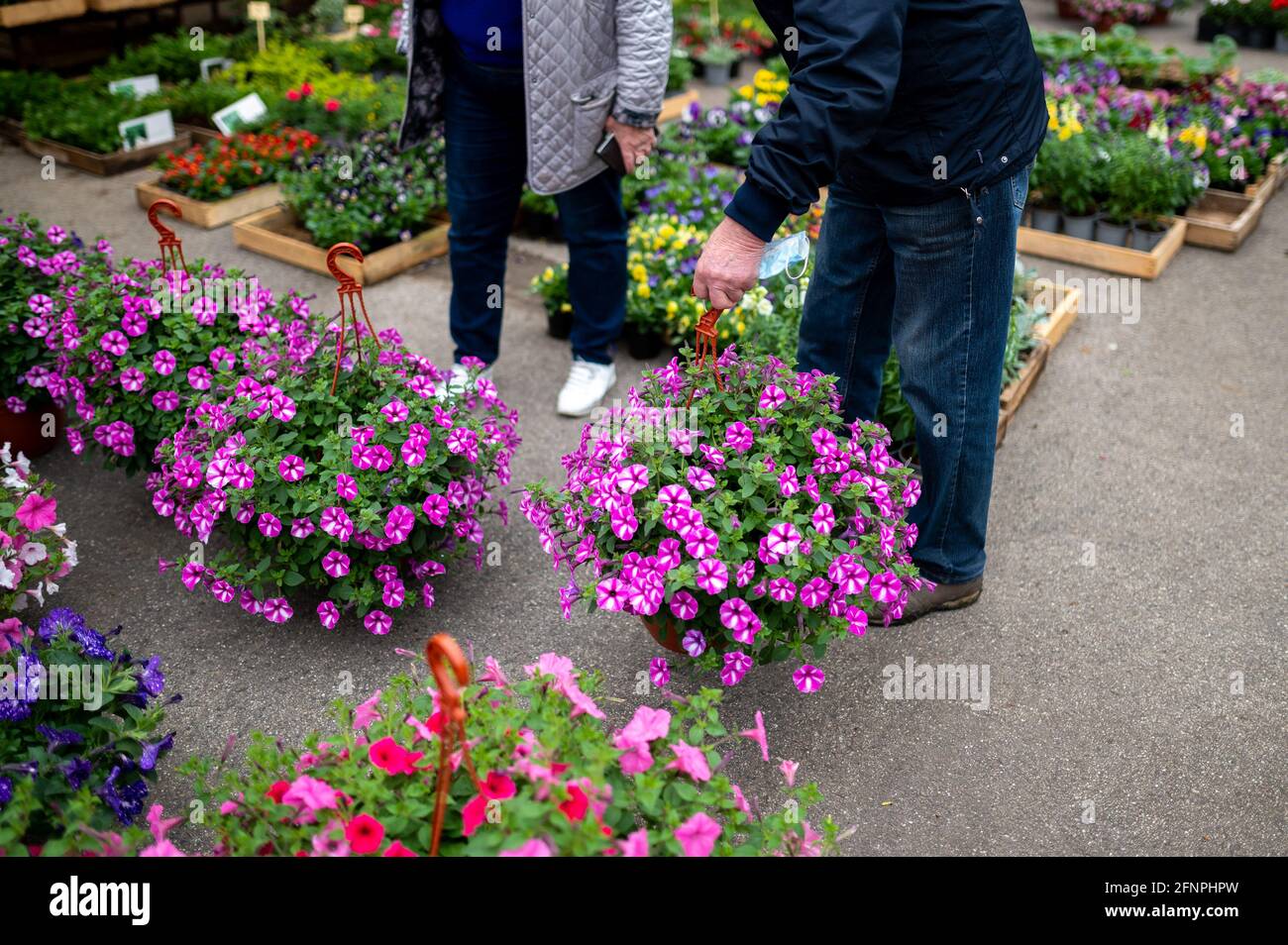 Colourful scene at spring flower market with people shopping for spring ...