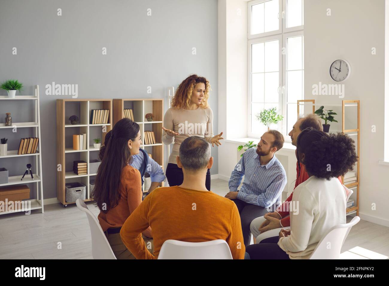 Different people at a support group meeting listen to a woman who ...