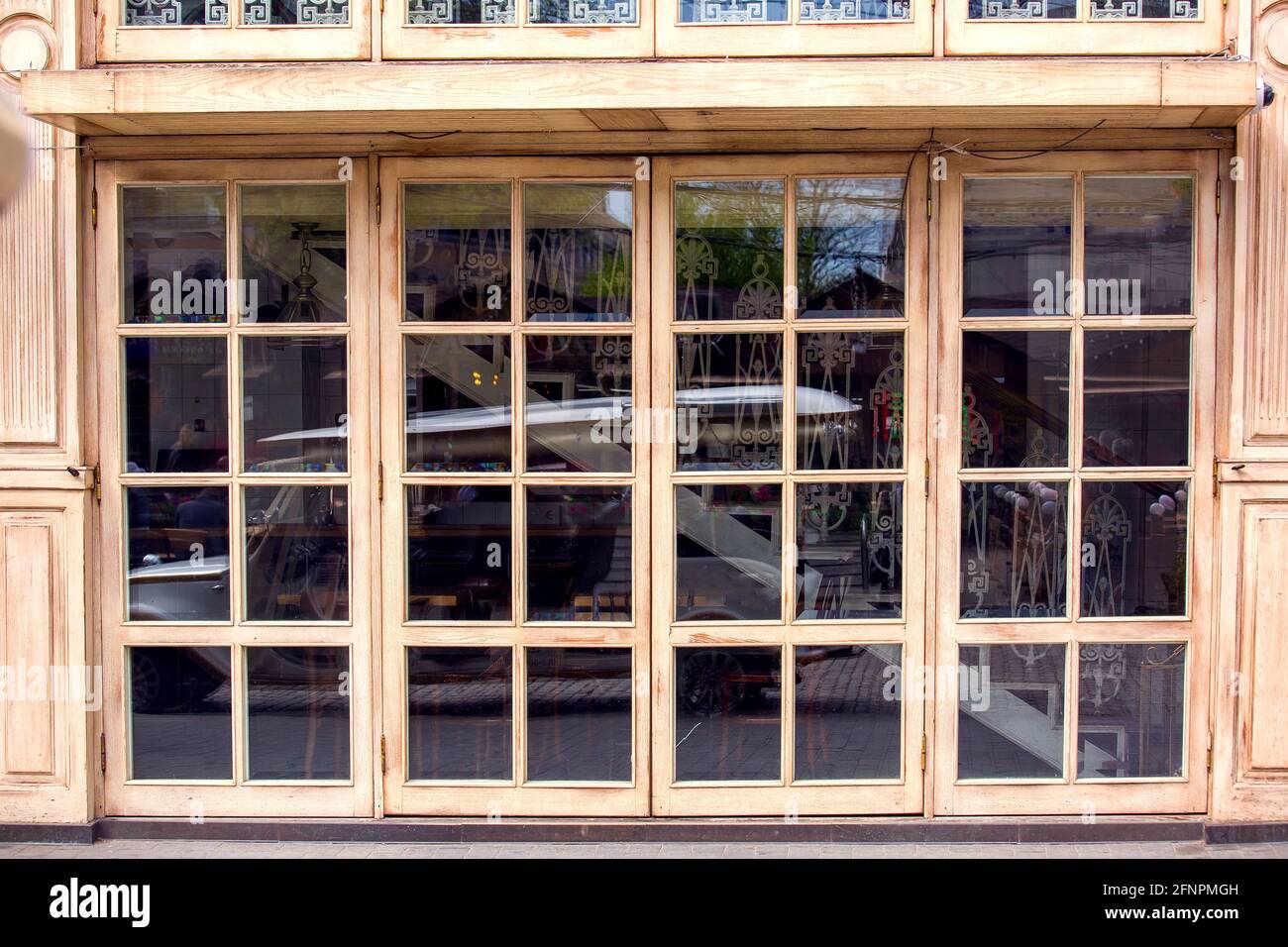 the facade of the restaurant with panoramic beige wooden windows and ...