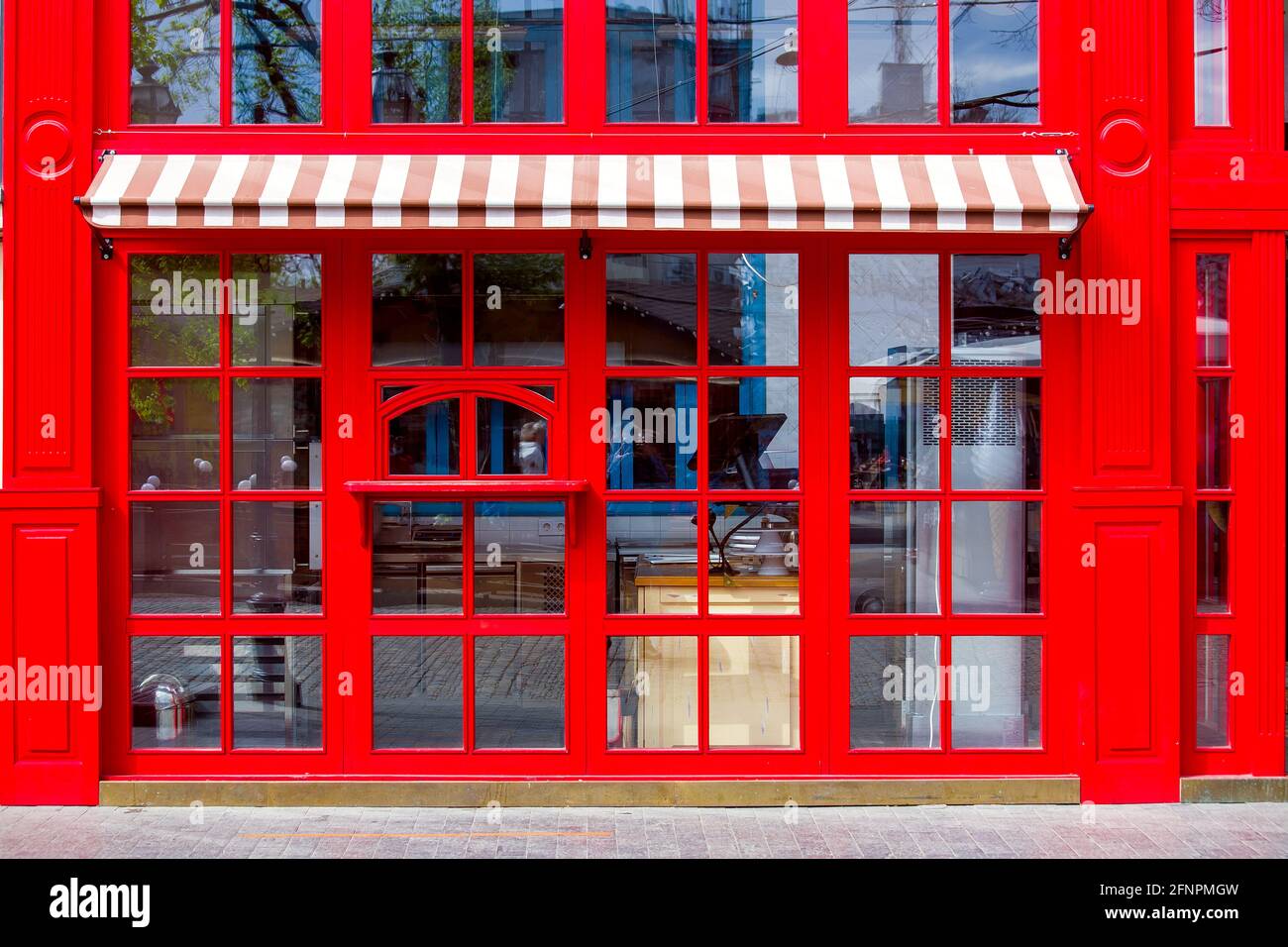 the facade of the restaurant with panoramic red wooden windows and a ...