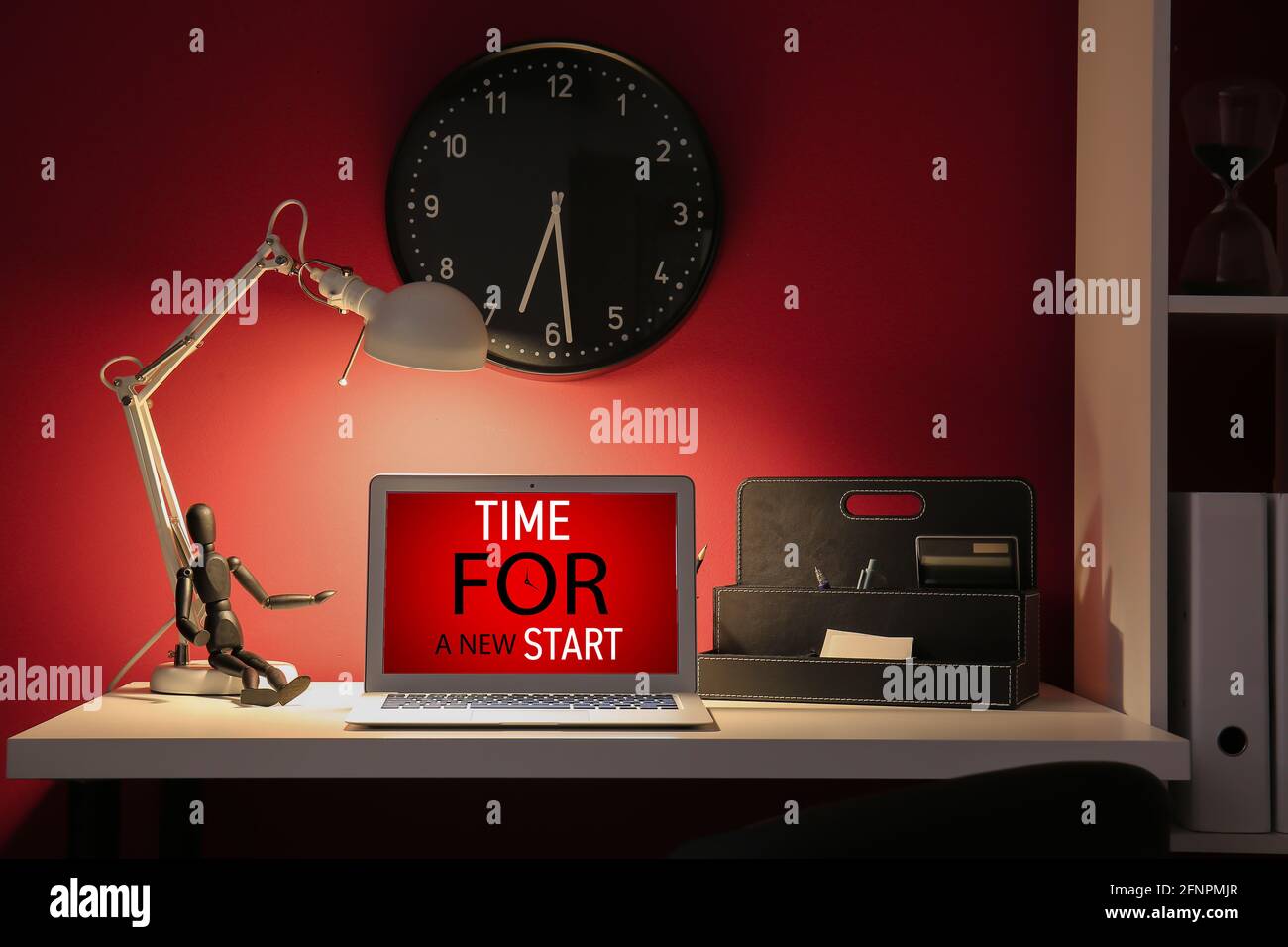 Text TIME FOR A NEW START on screen of laptop at workplace in office ...