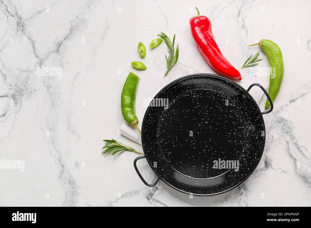 Clean frying pan with chili pepper and herbs on white background Stock ...