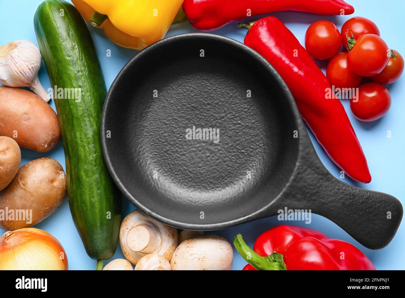Clean frying pan with products on color background Stock Photo - Alamy