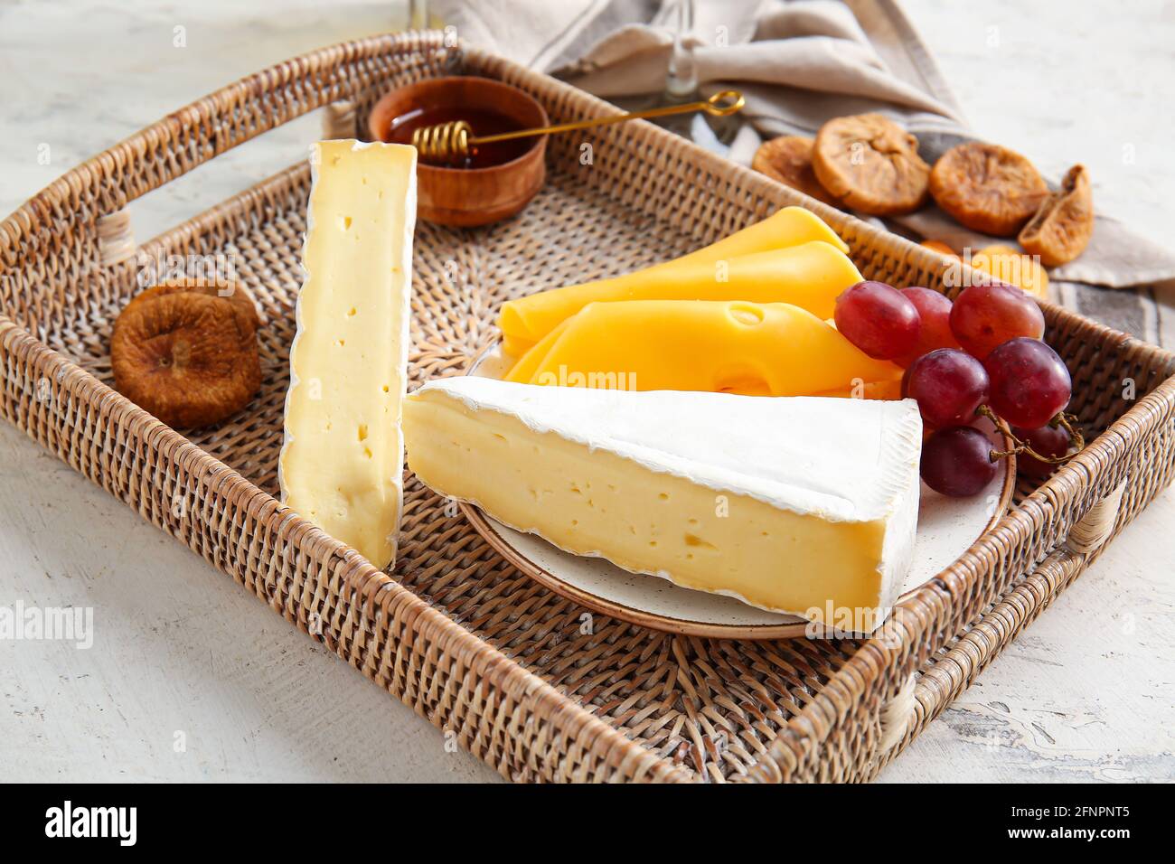 Tray with different types of cheese, honey, grapes and dried figs on ...