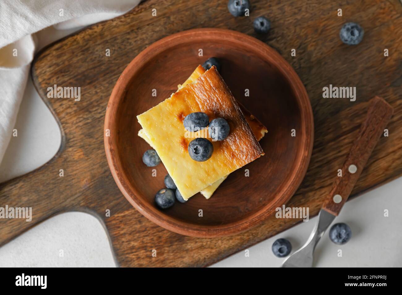 Plate with pieces of cottage cheese casserole on board Stock Photo - Alamy