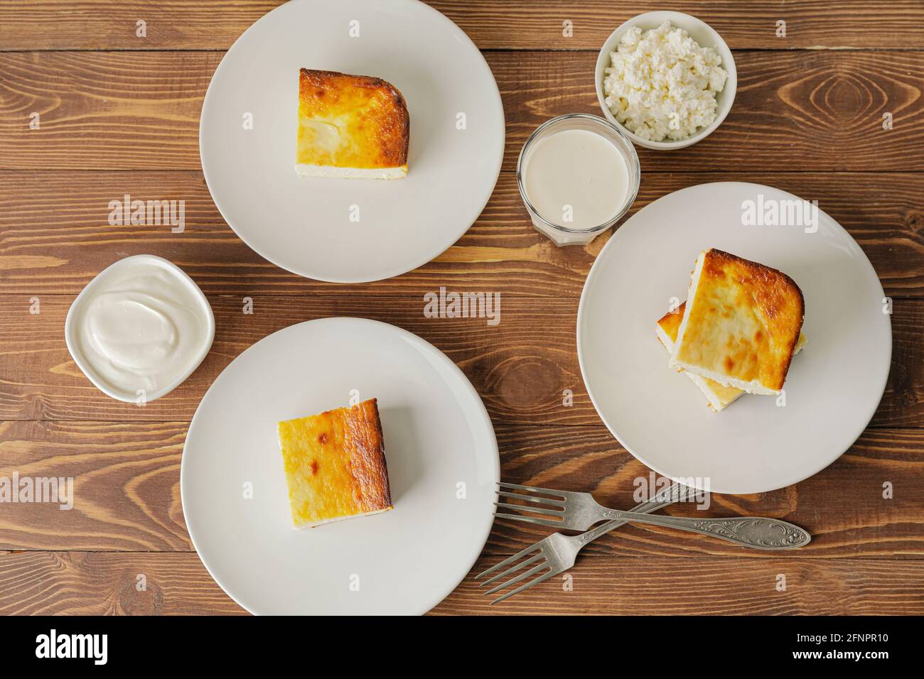 Plates with pieces of cottage cheese casserole on wooden background ...
