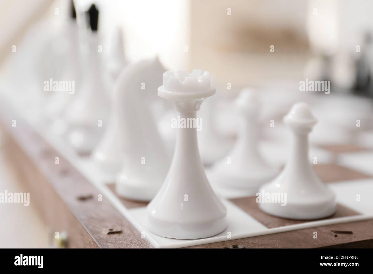 Chess pieces with game board on blurred background Stock Photo - Alamy