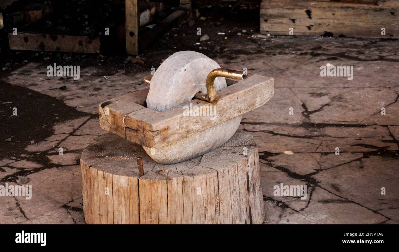 An old grinder in an authentic smithy. Weapon making in ancient times ...