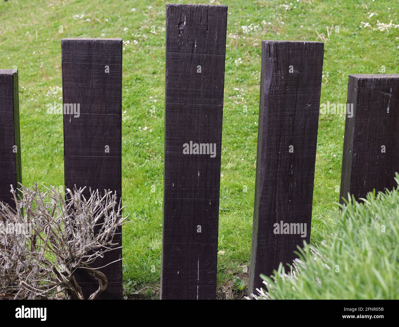 Garden post as a feature, between lawn and shrubs Stock Photo - Alamy