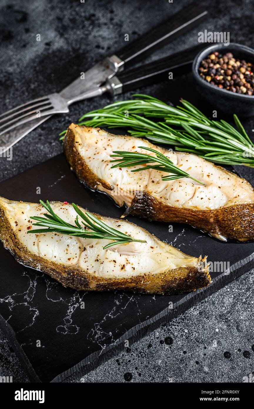 Halibut fish steak with rosemary. Black background. Top view Stock ...
