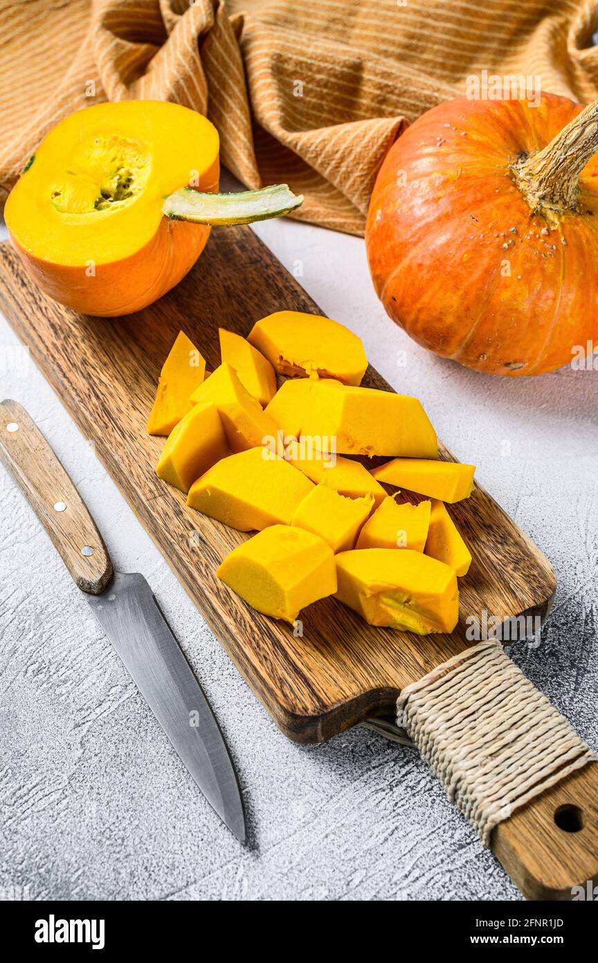 Sliced raw orange pumpkin on a chopping Board. White background. Top ...