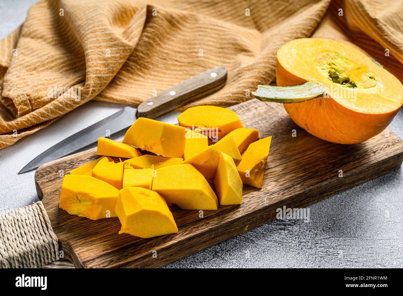 Raw pumpkin cubes on a cutting Board. White background. Top view Stock ...