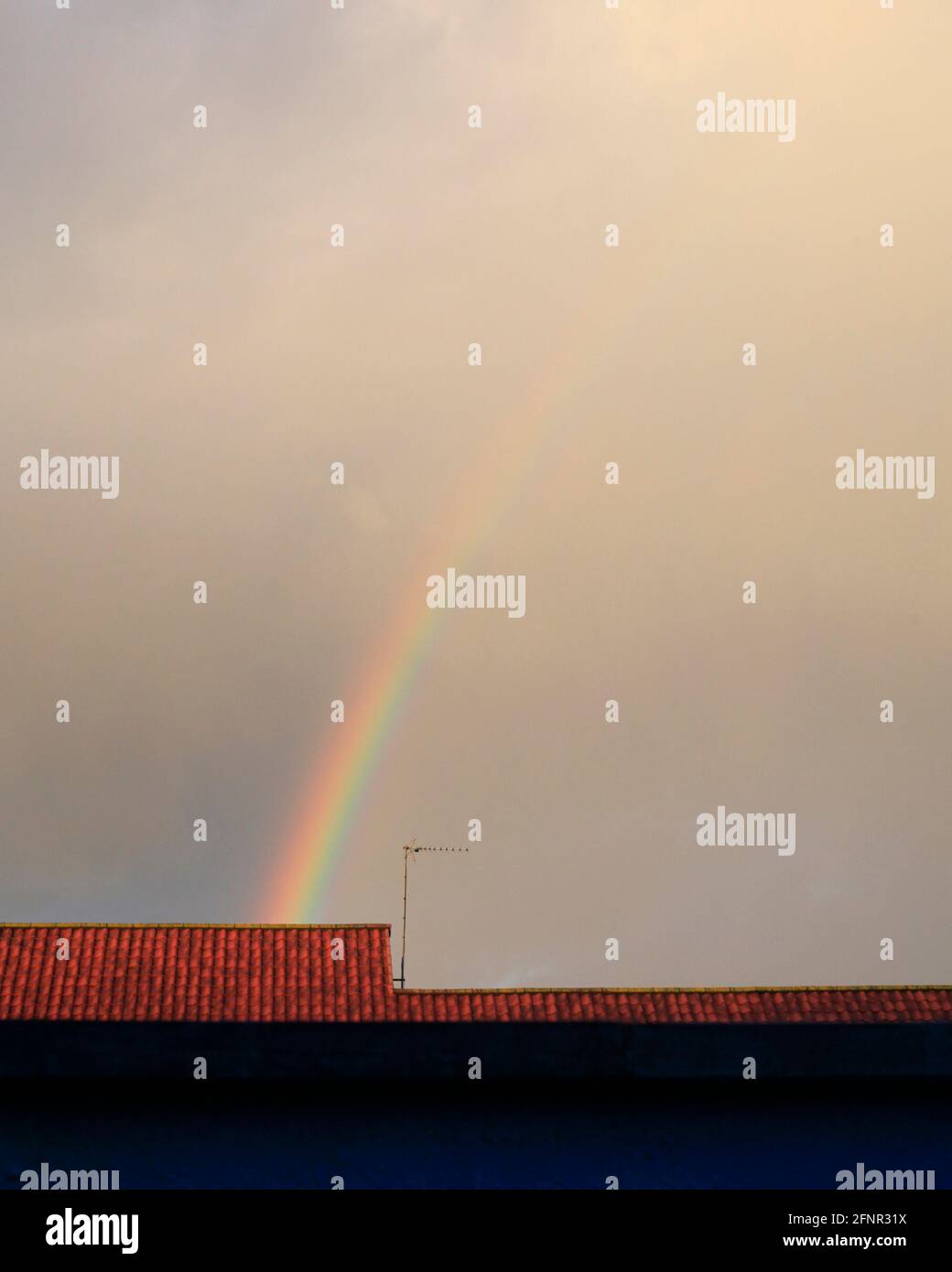 Rainbow over red roof against grey sky hi-res stock photography and ...