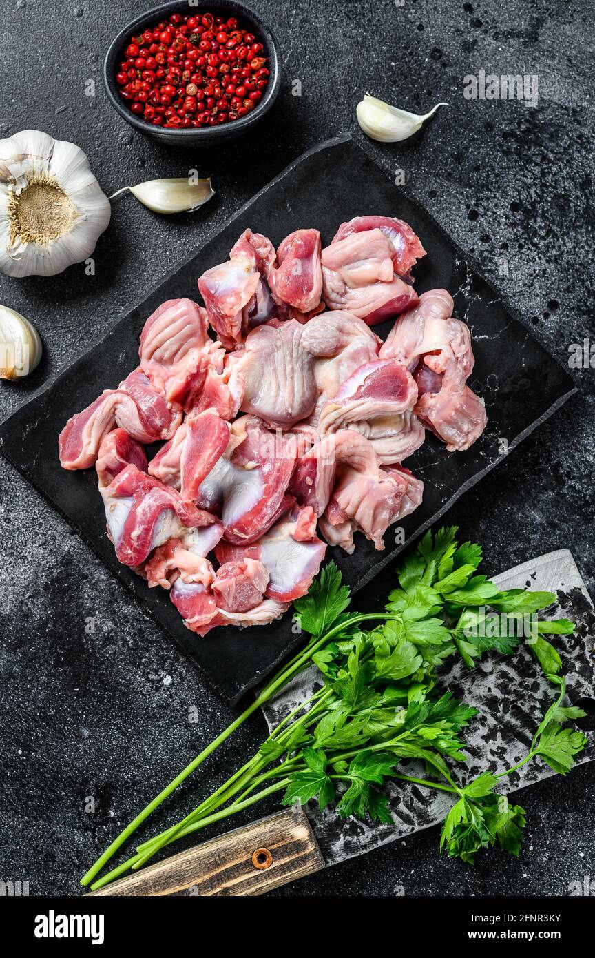 Raw uncooked Bird chicken giblets gizzards, stomachs. Black background ...