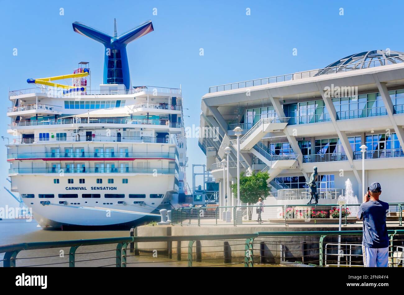 A tourist photographs the Carnival Sensation as it is docked at the ...