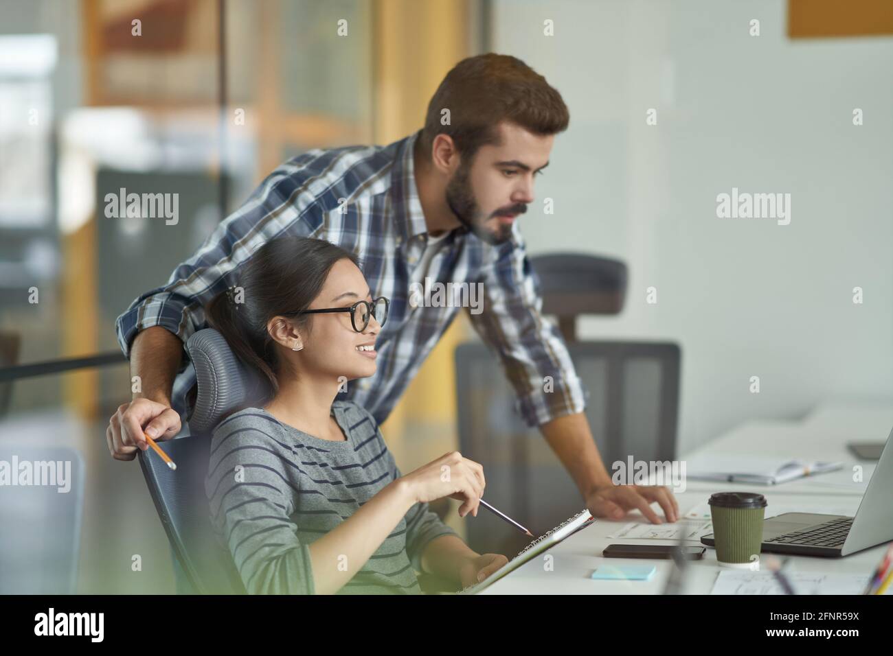 Professional male mentor or teacher explaining computer work to young ...