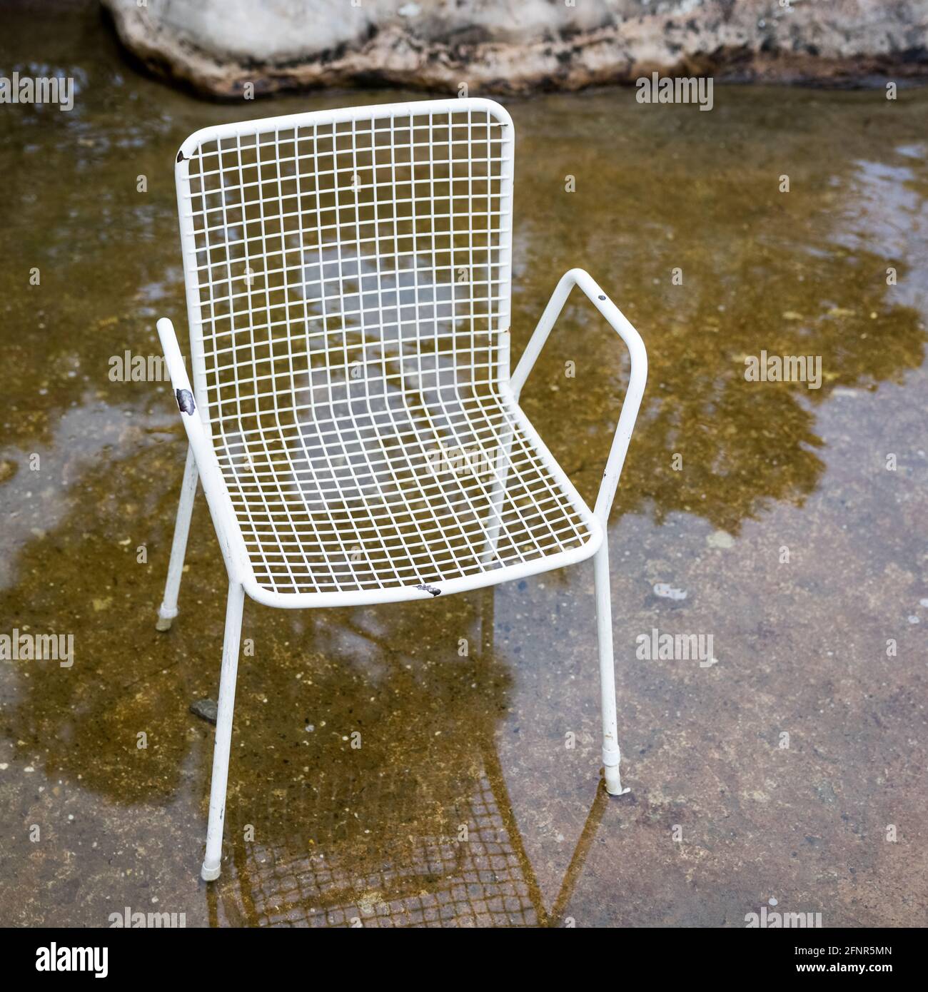 Closeup shot of a white metallic grid chair put on a water Stock Photo ...