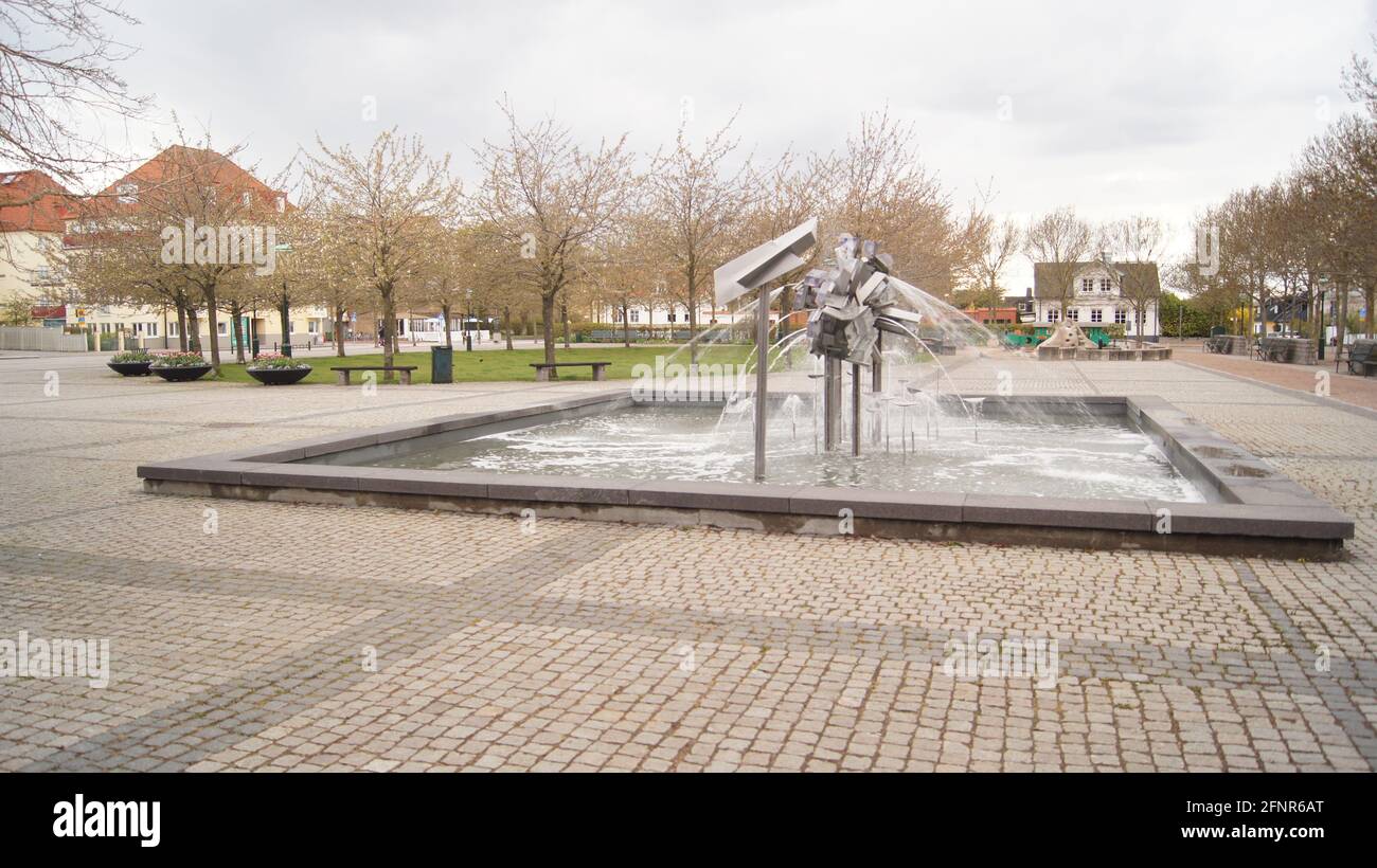 Beautiful sunny park with paved ground and a large square fountain ...