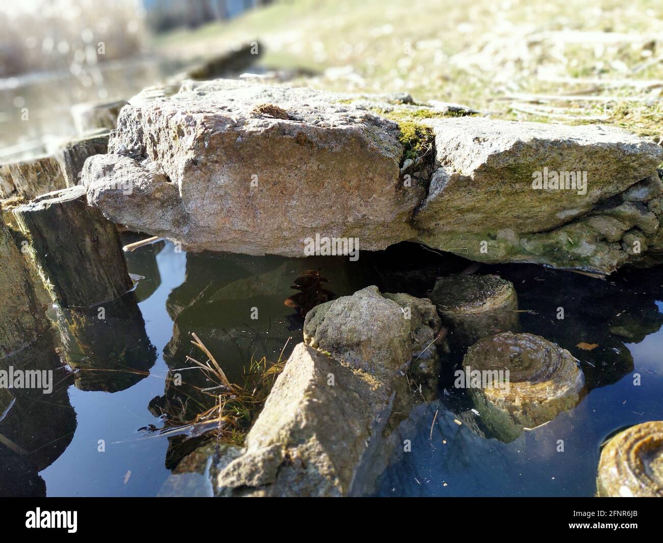 Closeup of a rough slab of stone with wooden beams submerged in the ...