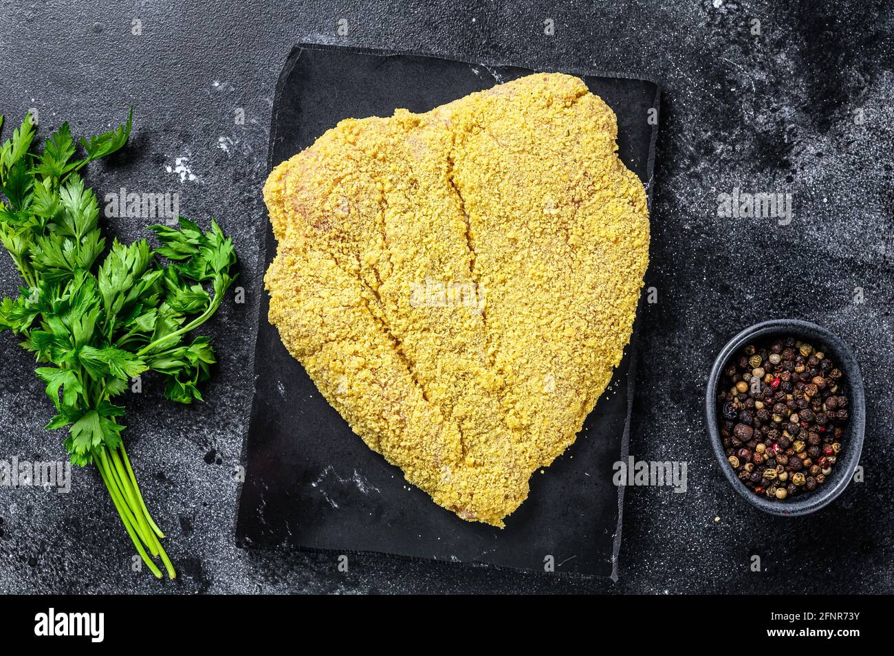 Raw Breaded German Weiner Schnitzel. Black background. Top view Stock ...