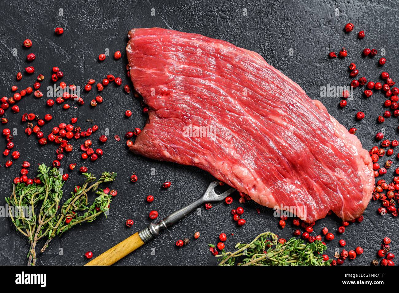 Raw Flank steak with rosemary and pink salt. Fresh Marble beef meat black Angus. Black ...