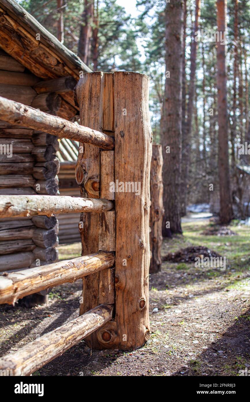 Large wooden fence posts that enclose an old wooden house in the forest ...