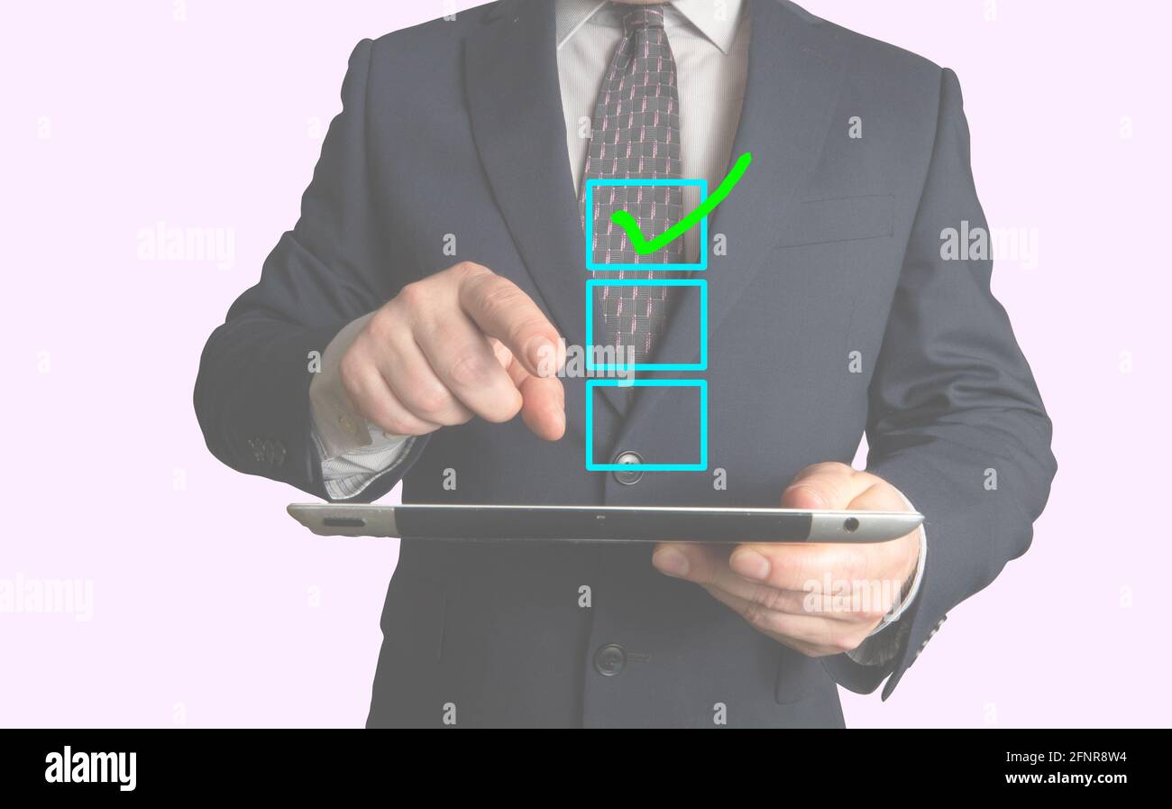 Businessman about to touch a tablet to tick a completed task on a ...