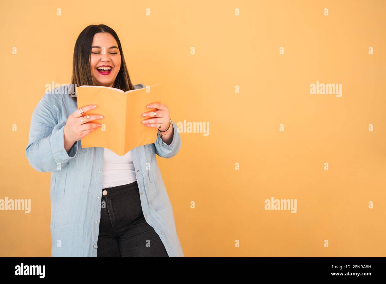 Young plus size woman reading a book Stock Photo - Alamy