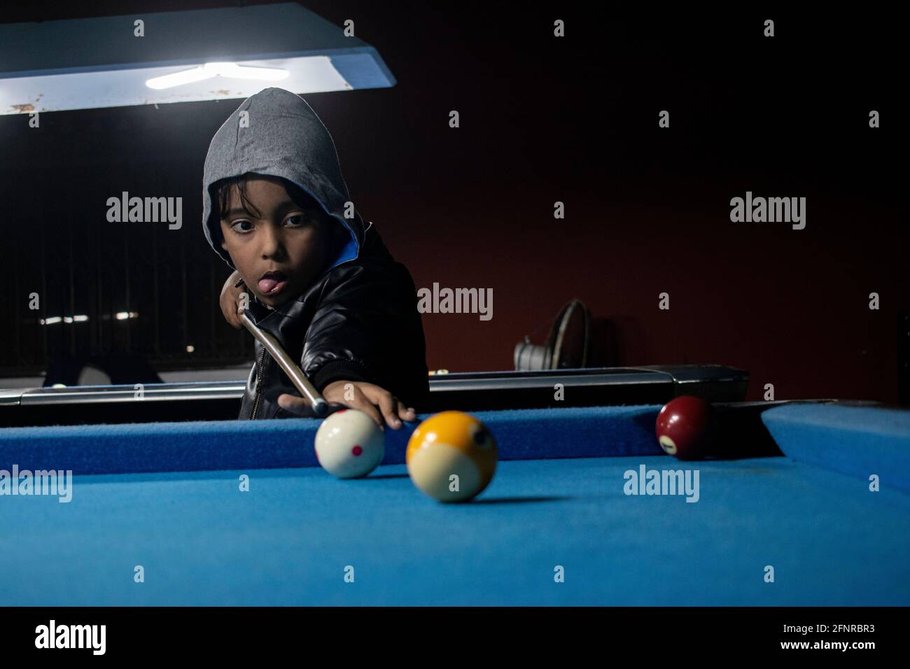 Kid playing pool Stock Photo - Alamy