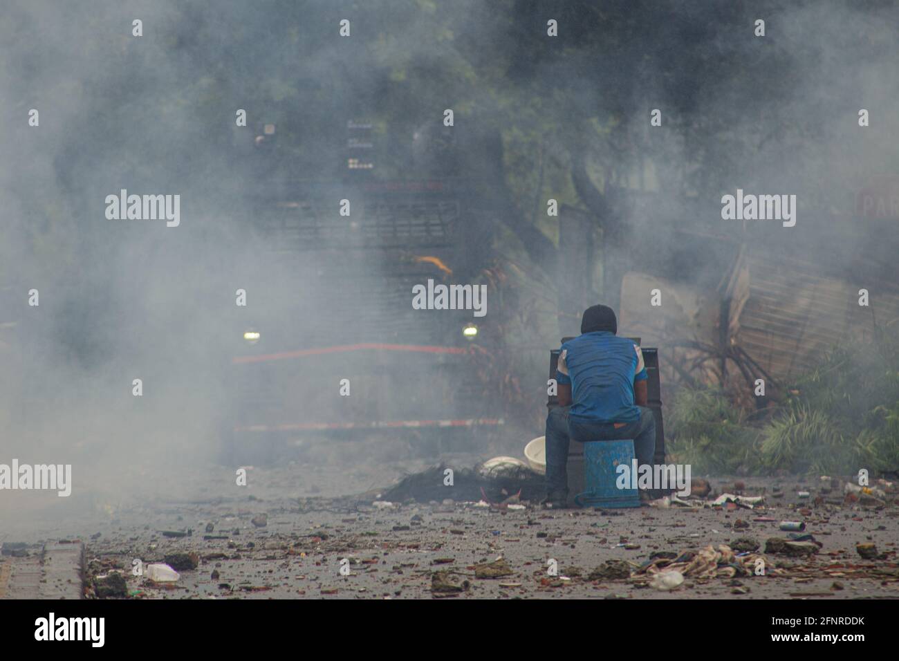 Demonstrators take cover behind a homemade shield in front of a riot ...