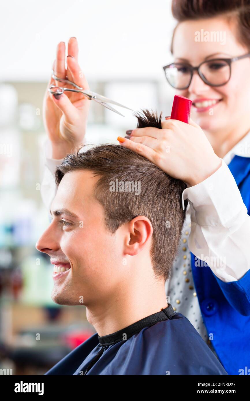 Female coiffeur cutting men hair in hairdresser shop Stock Photo - Alamy
