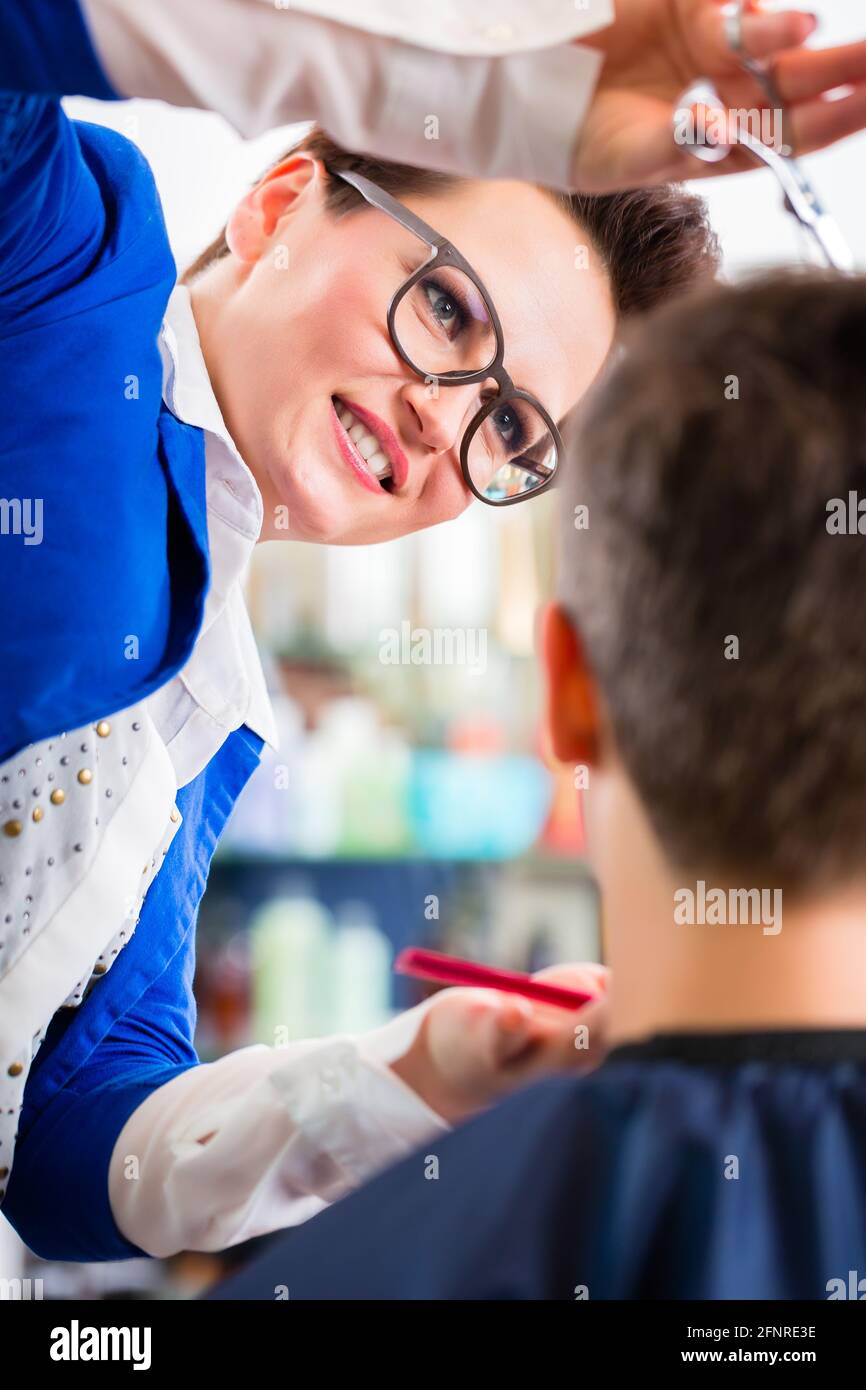 Female coiffeur cutting men hair in hairdresser shop Stock Photo - Alamy