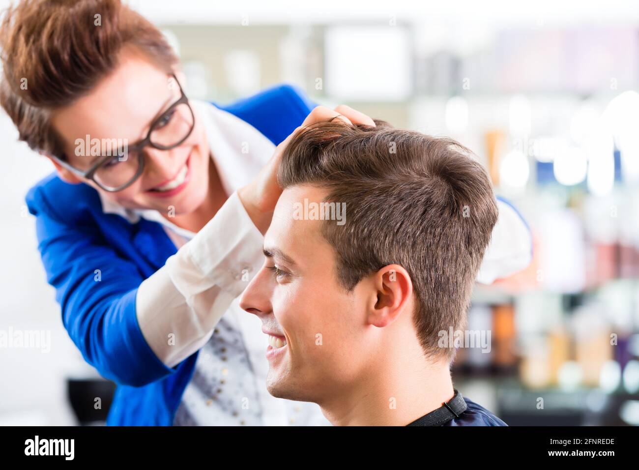 Female coiffeur cutting men hair in hairdresser shop Stock Photo - Alamy