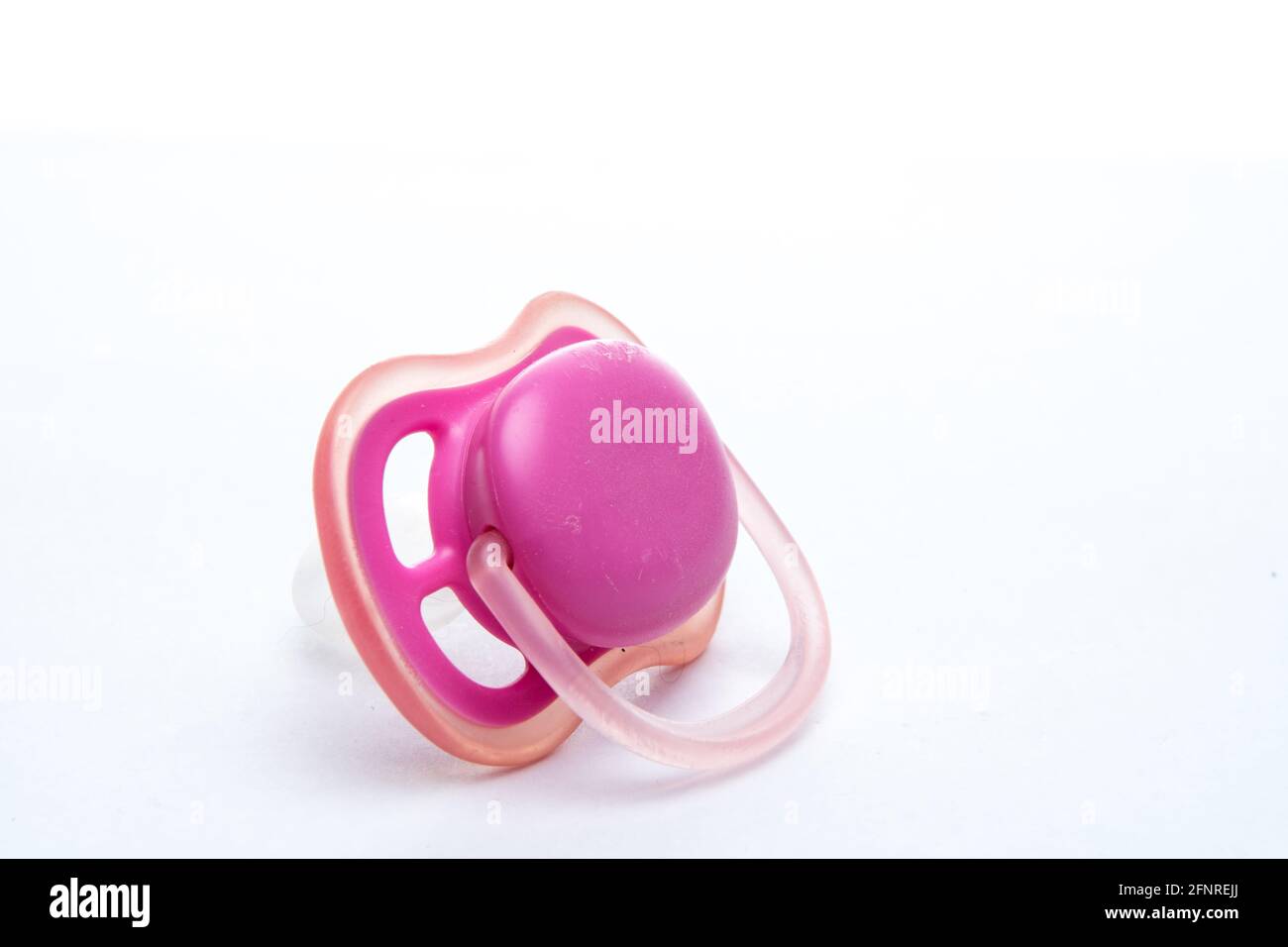 Pink baby's orthodontic pacifier isolated on white background. Side ...