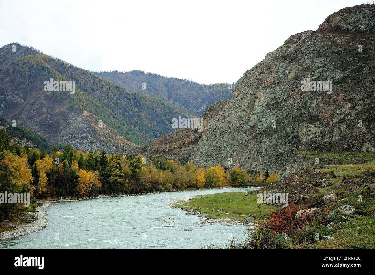 A winding bed of a beautiful turquoise river flowing through an autumn ...