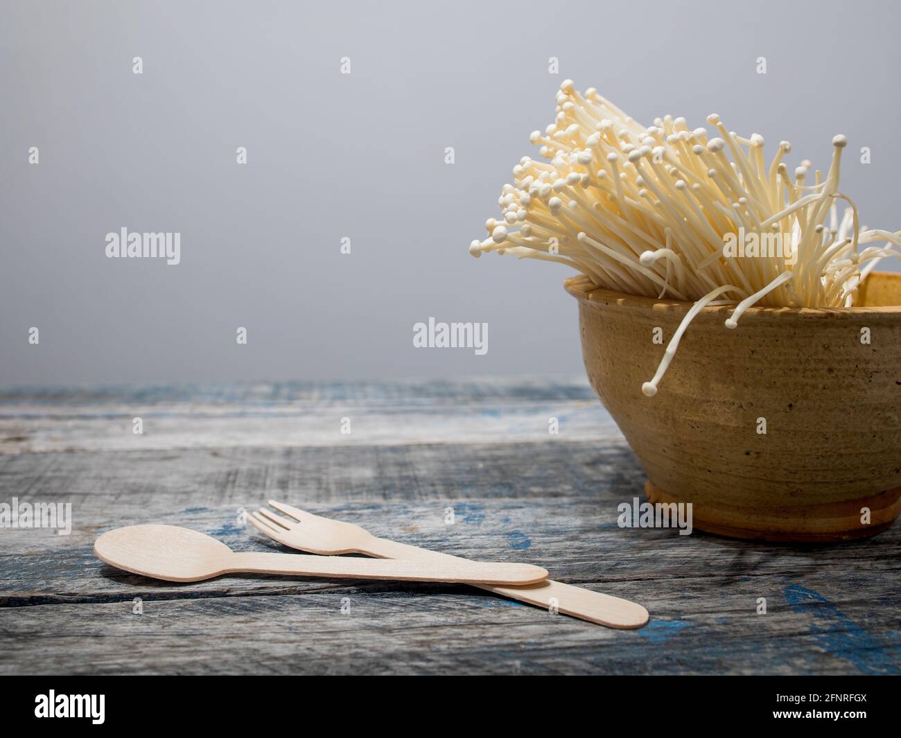 Enoki mushrooms in clay bowl on table Stock Photo - Alamy