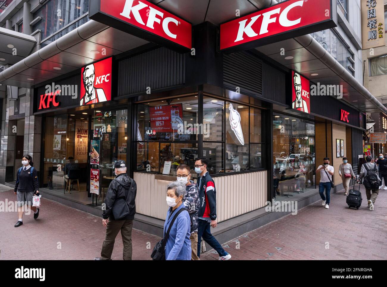 Pedestrians walk past an American fast food chicken restaurant chain ...