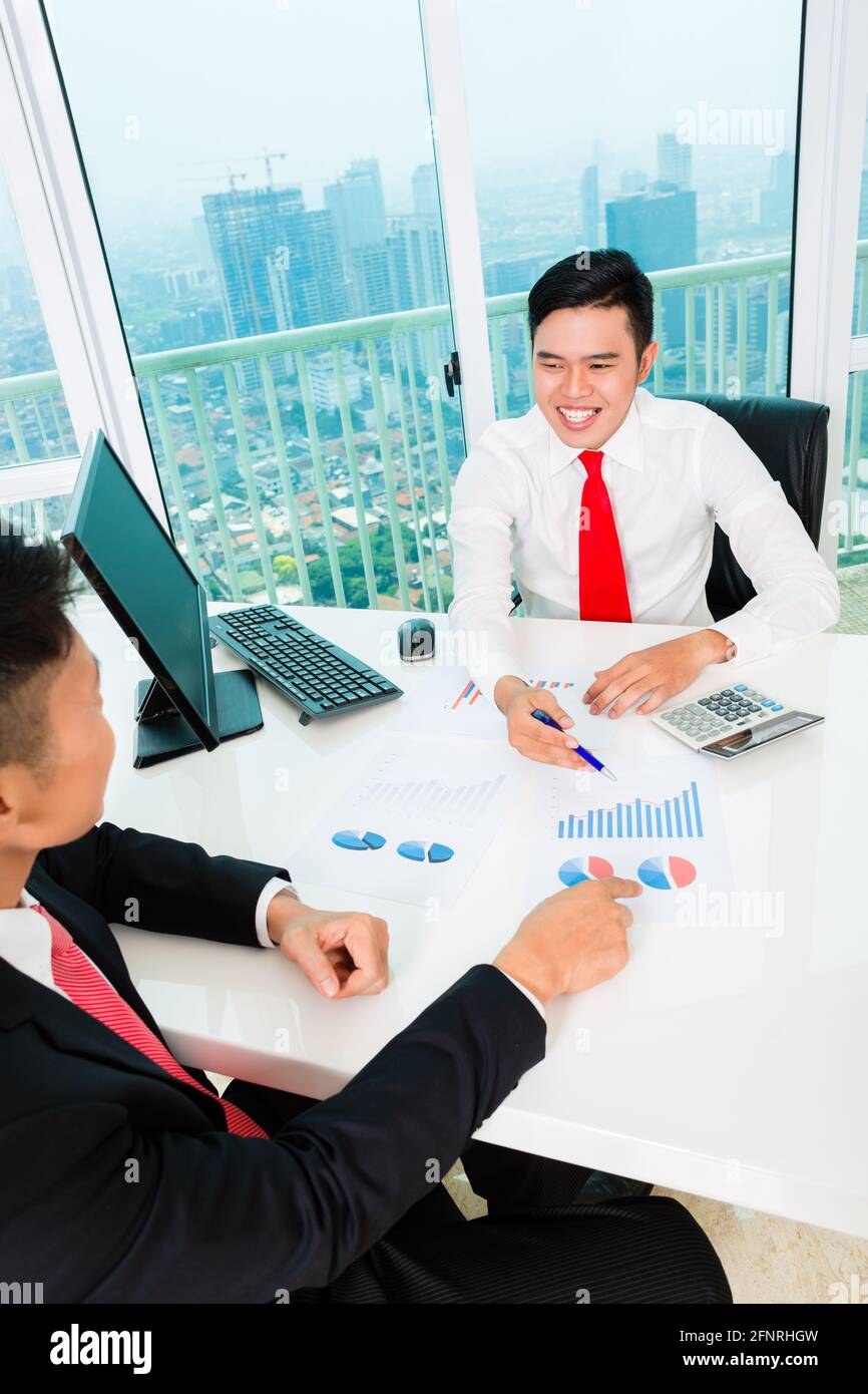 Asian banker offering client finance assets in bank office Stock Photo ...